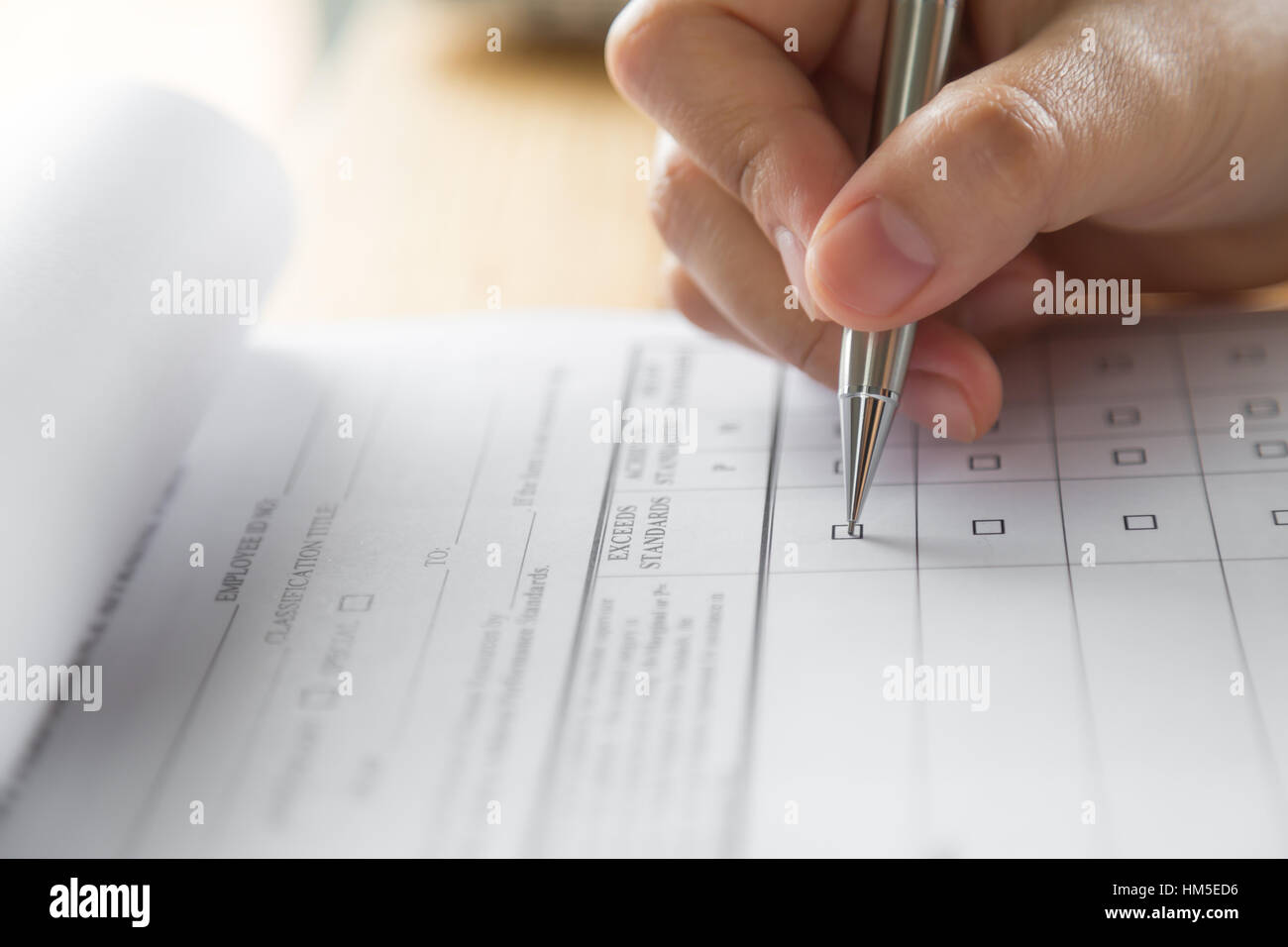 Hand with pen over application form Stock Photo - Alamy