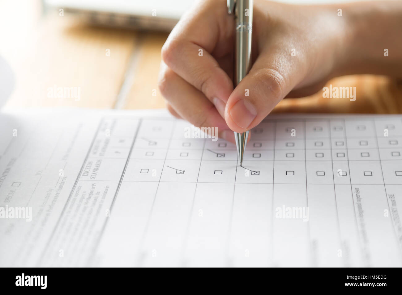Hand with pen over application form Stock Photo - Alamy