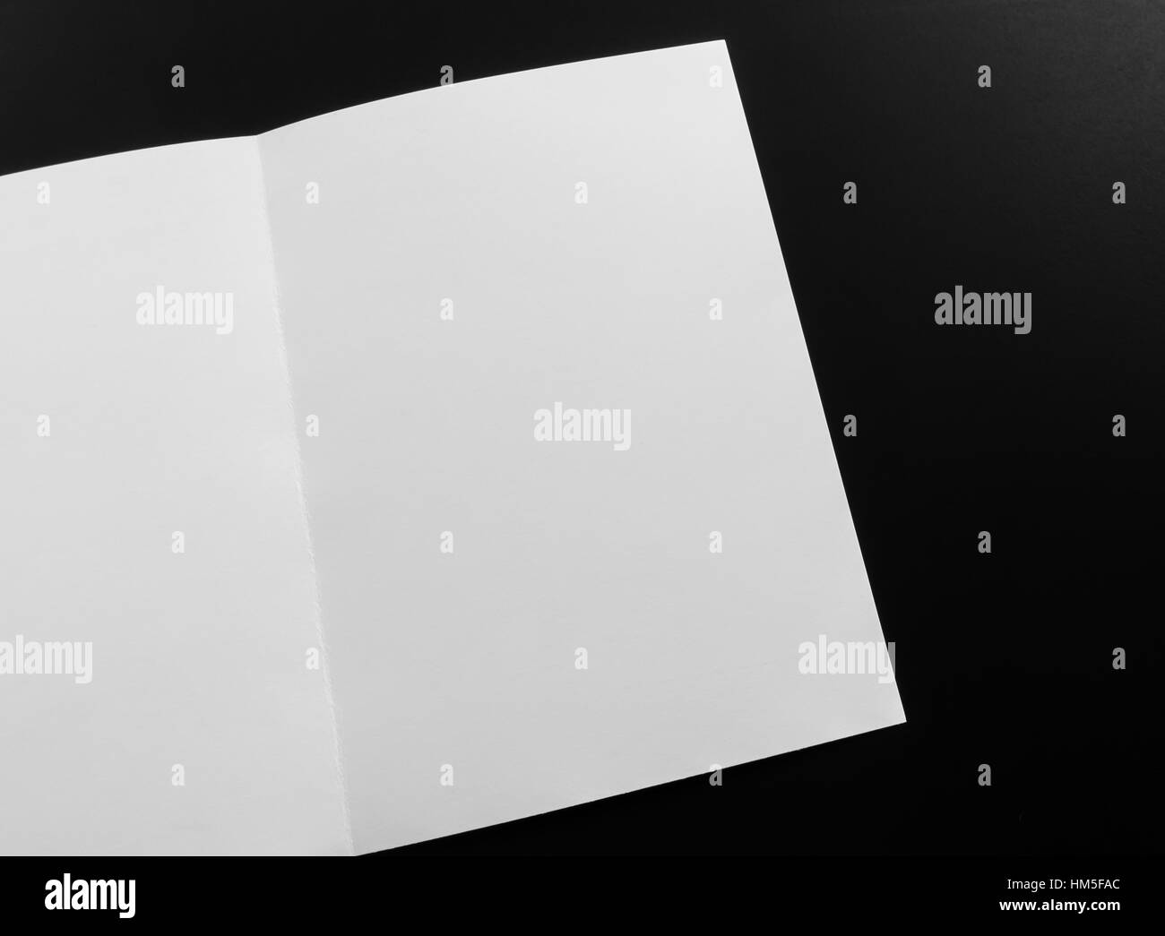 Bifold white template paper on black background Stock Photo - Alamy