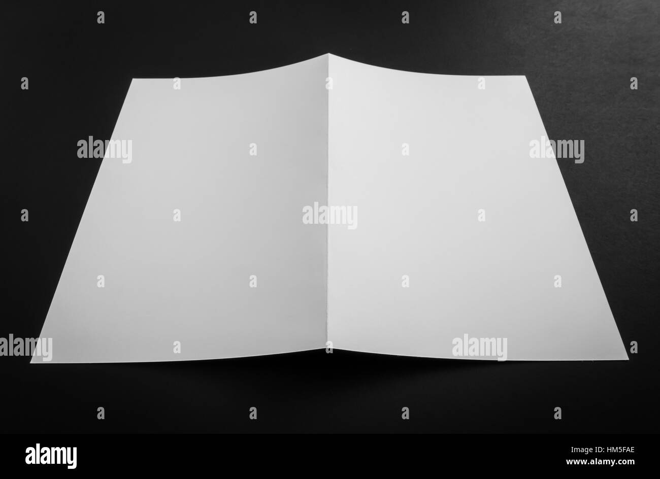 Bifold white template paper on black background Stock Photo - Alamy