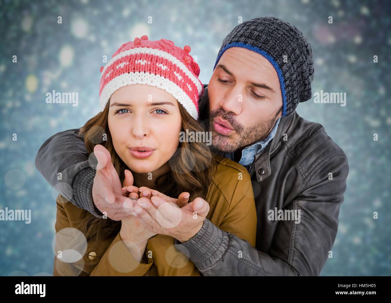 Couple blowing kisses against blue bokeh background Stock Photo - Alamy