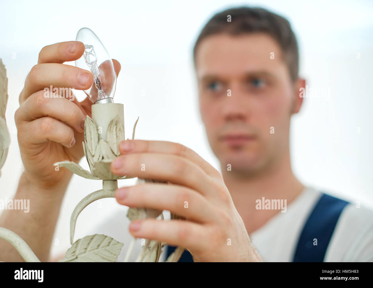 Male electrician changing lamp bulb Stock Photo - Alamy