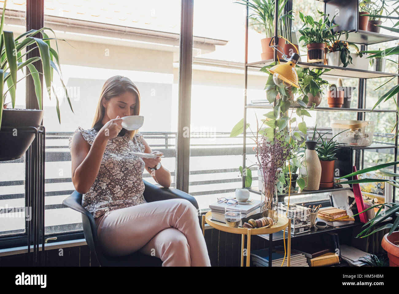 Businesswoman Drinking Coffee While Sitting On Chair In Home Office