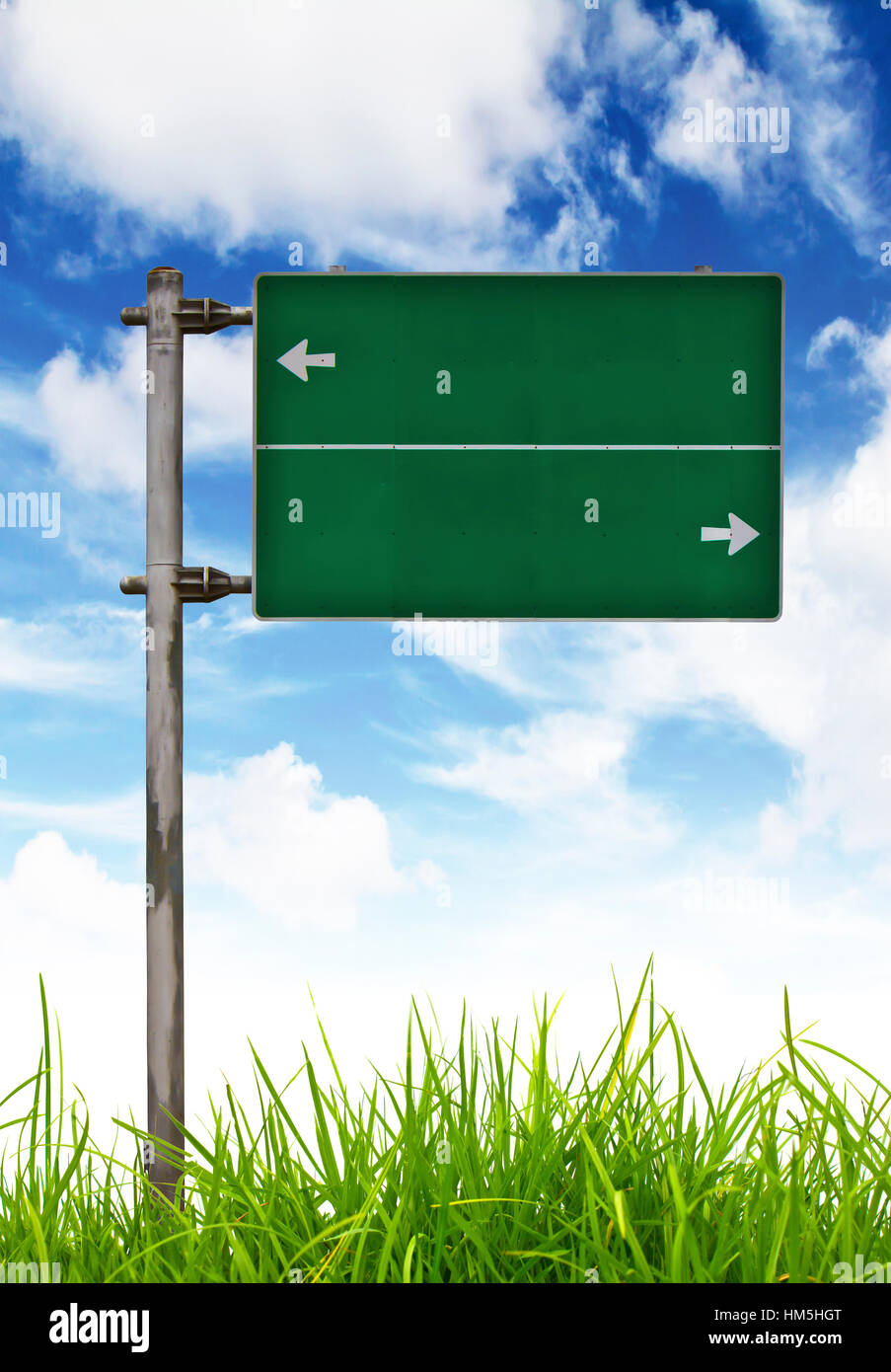 Green Traffic sign on green grass and blue sky Stock Photo - Alamy