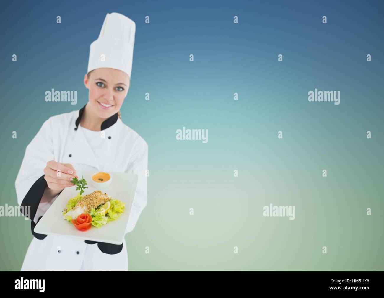 Happy female chef presenting food against turquoise background Stock ...