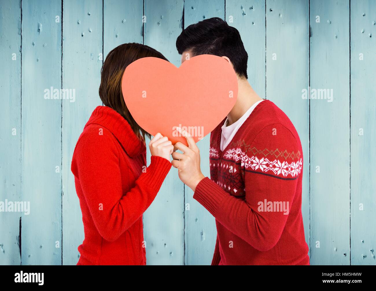 Romantic couple hiding their face behind heart Stock Photo - Alamy