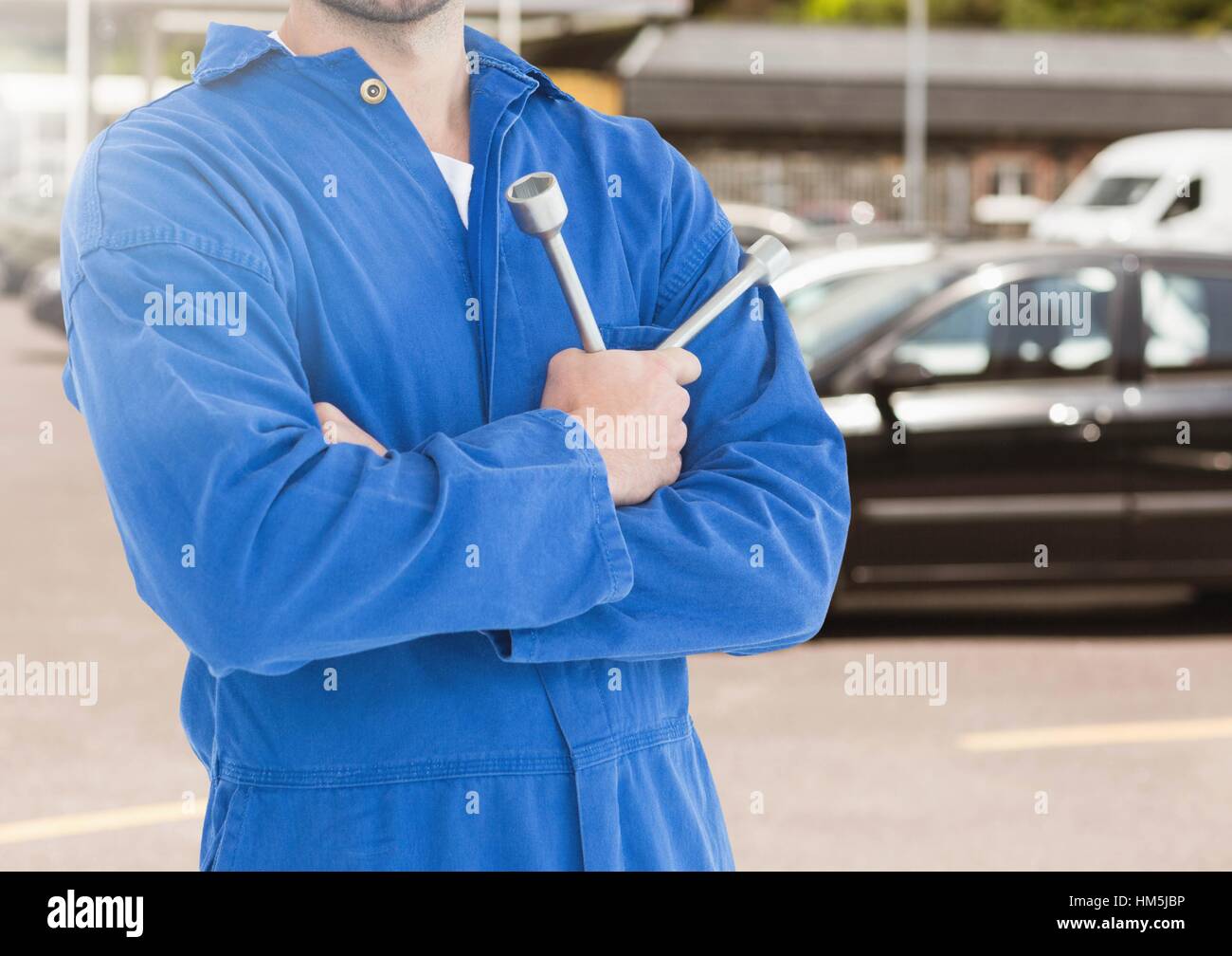 Mid section of mechanic holding tool Stock Photo - Alamy