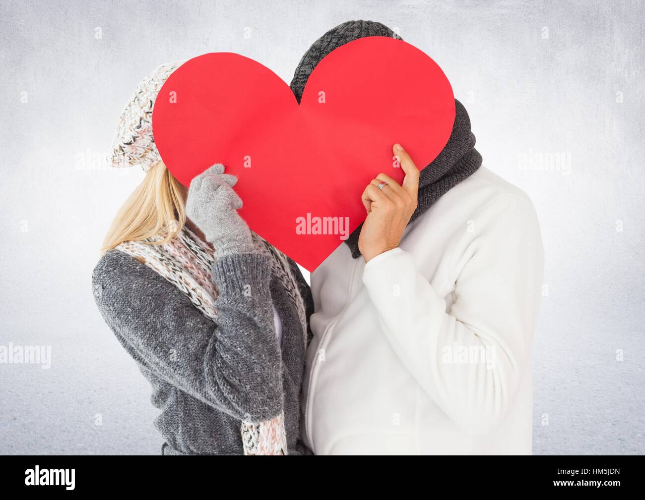 Couple hiding their face behind red heart Stock Photo - Alamy