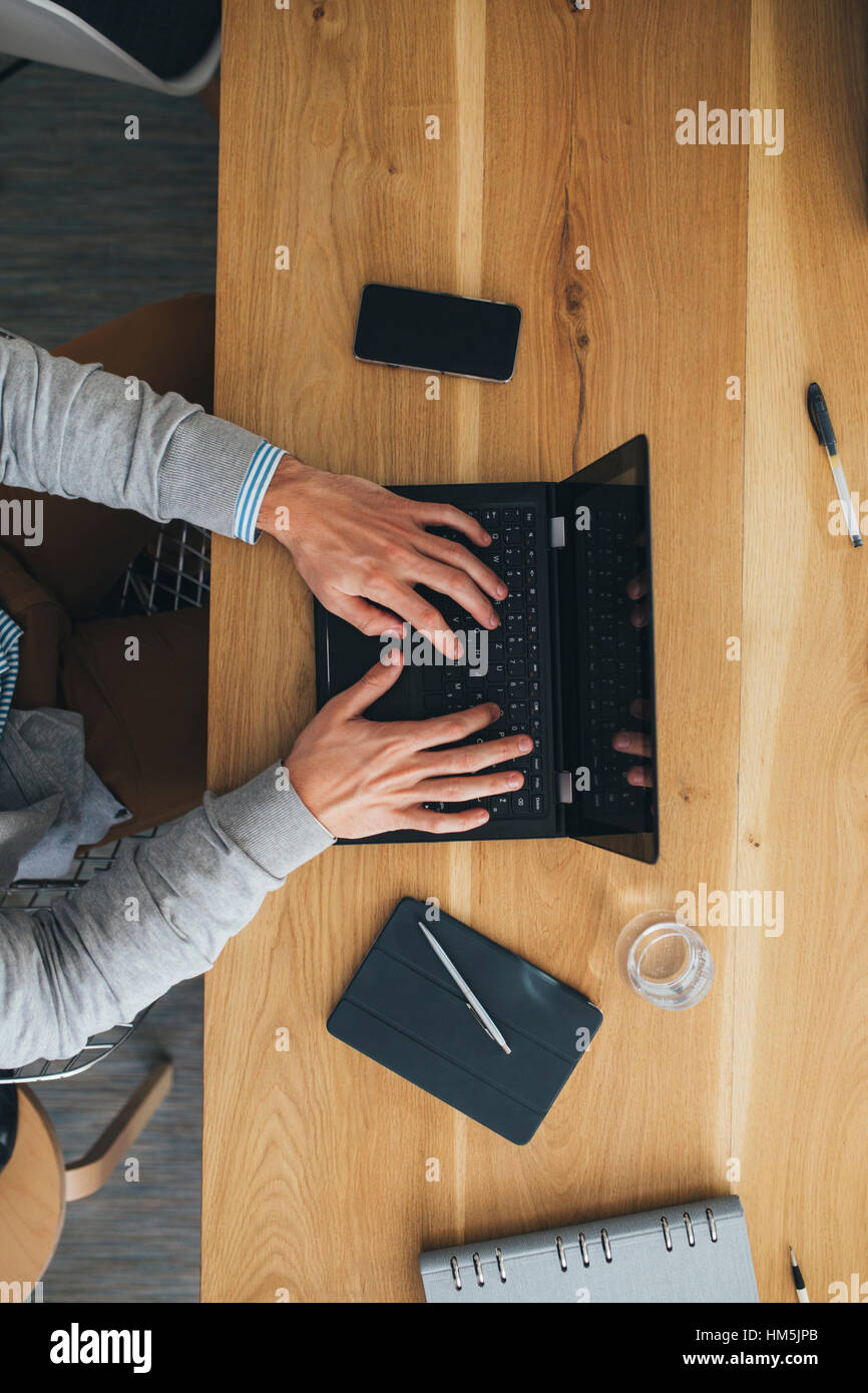 Overhead view of businessman using laptop computer while sitting at ...