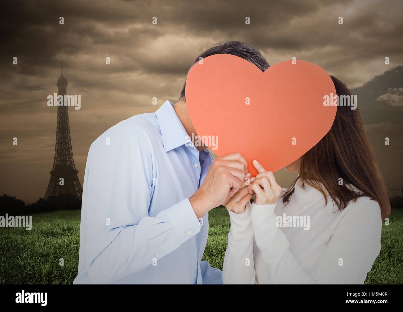 Romantic couple hiding their face behind heart Stock Photo - Alamy