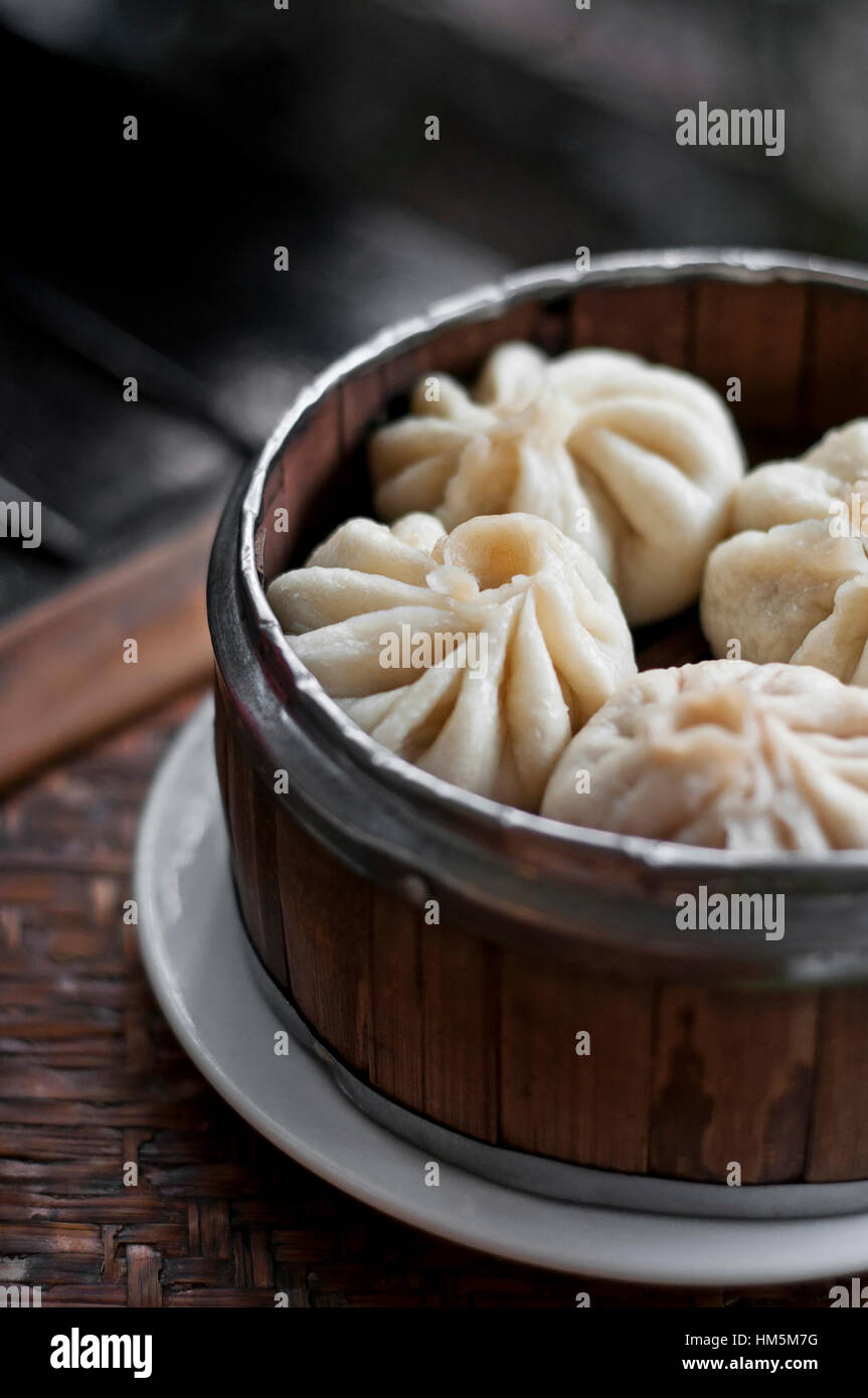 Close-up of dumplings in bamboo container with plate on table Stock ...