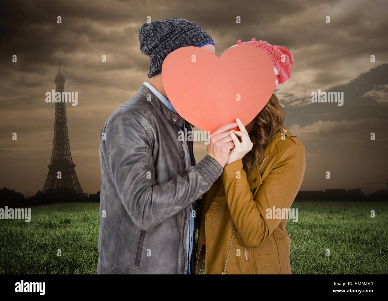 Romantic couple hiding their face behind heart Stock Photo - Alamy