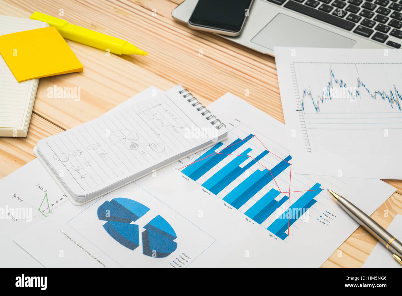 Financial charts on the table with laptop Stock Photo - Alamy