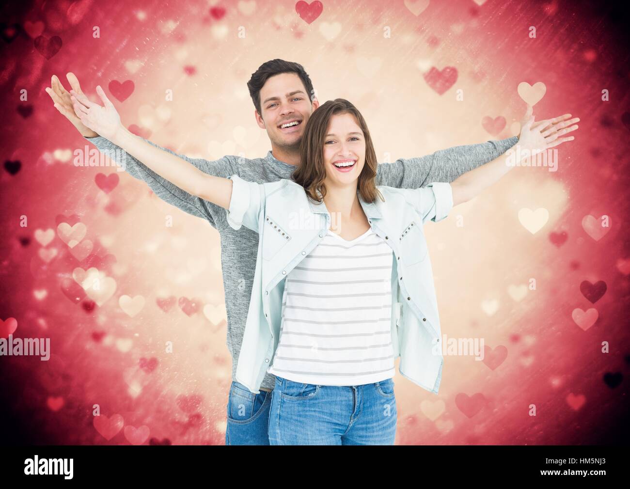 Portrait of couple standing with arms outstretched Stock Photo - Alamy