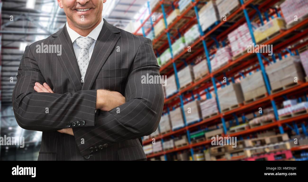 Businessman standing with arms crossed at warehouse Stock Photo - Alamy