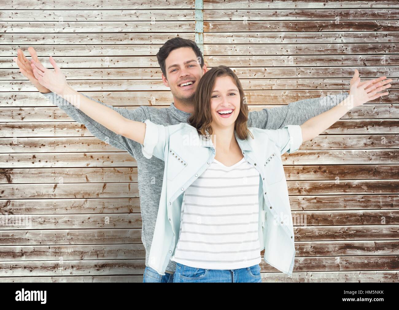 Portrait of happy couple standing with arms outstretched Stock Photo ...
