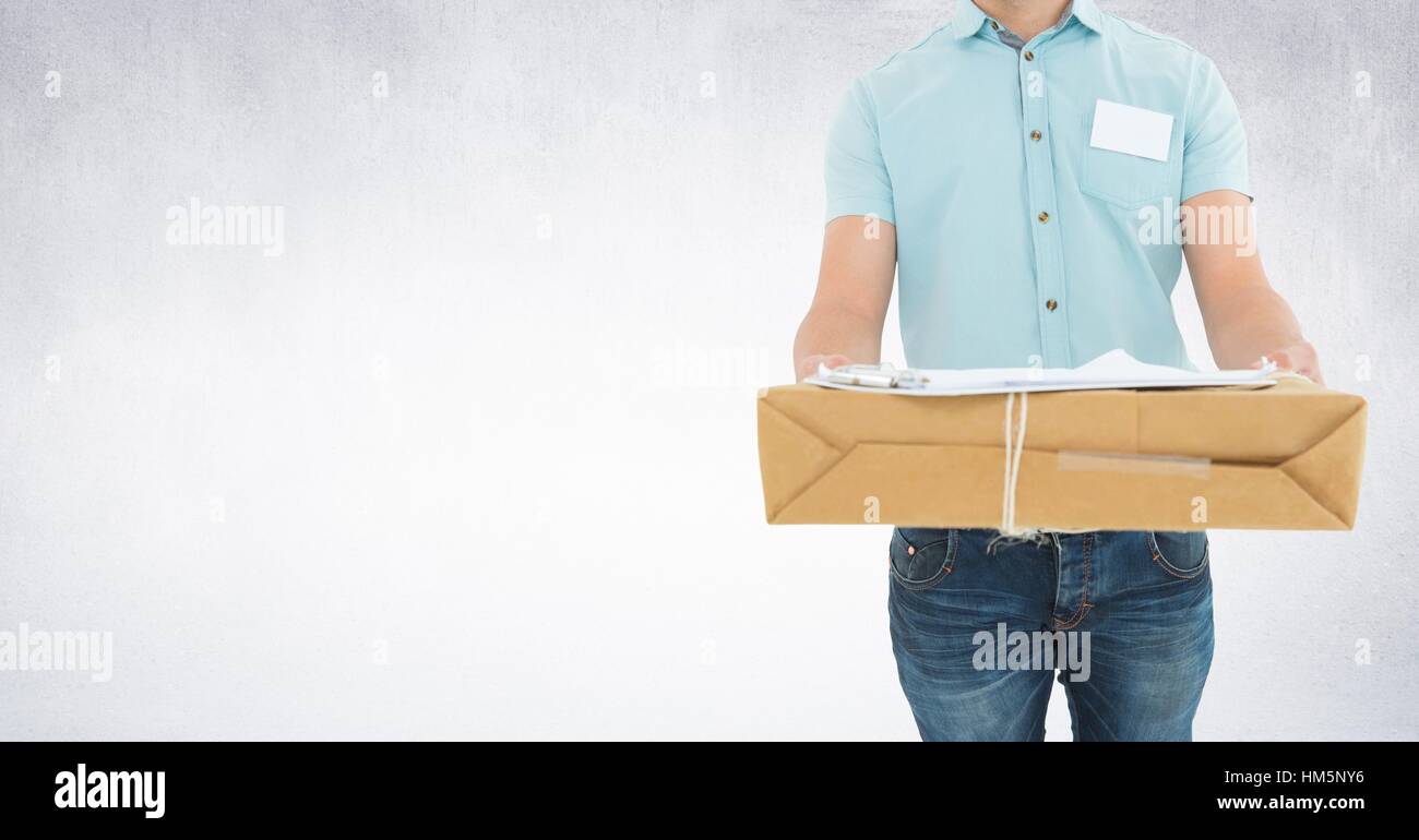 Delivery man holding box against grey background Stock Photo - Alamy