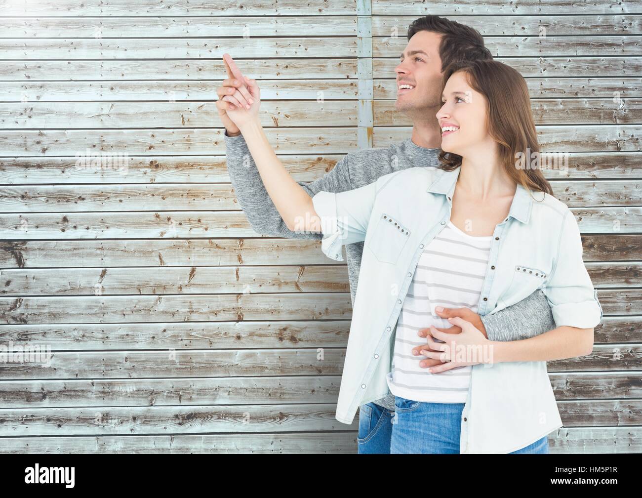 Happy couple pointing at distance Stock Photo - Alamy