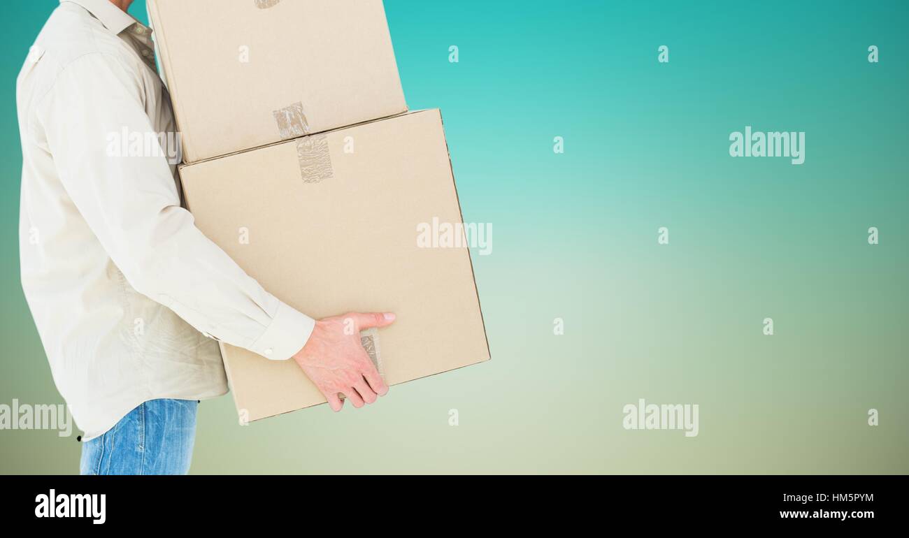 Delivery man carrying boxes against blue background Stock Photo - Alamy