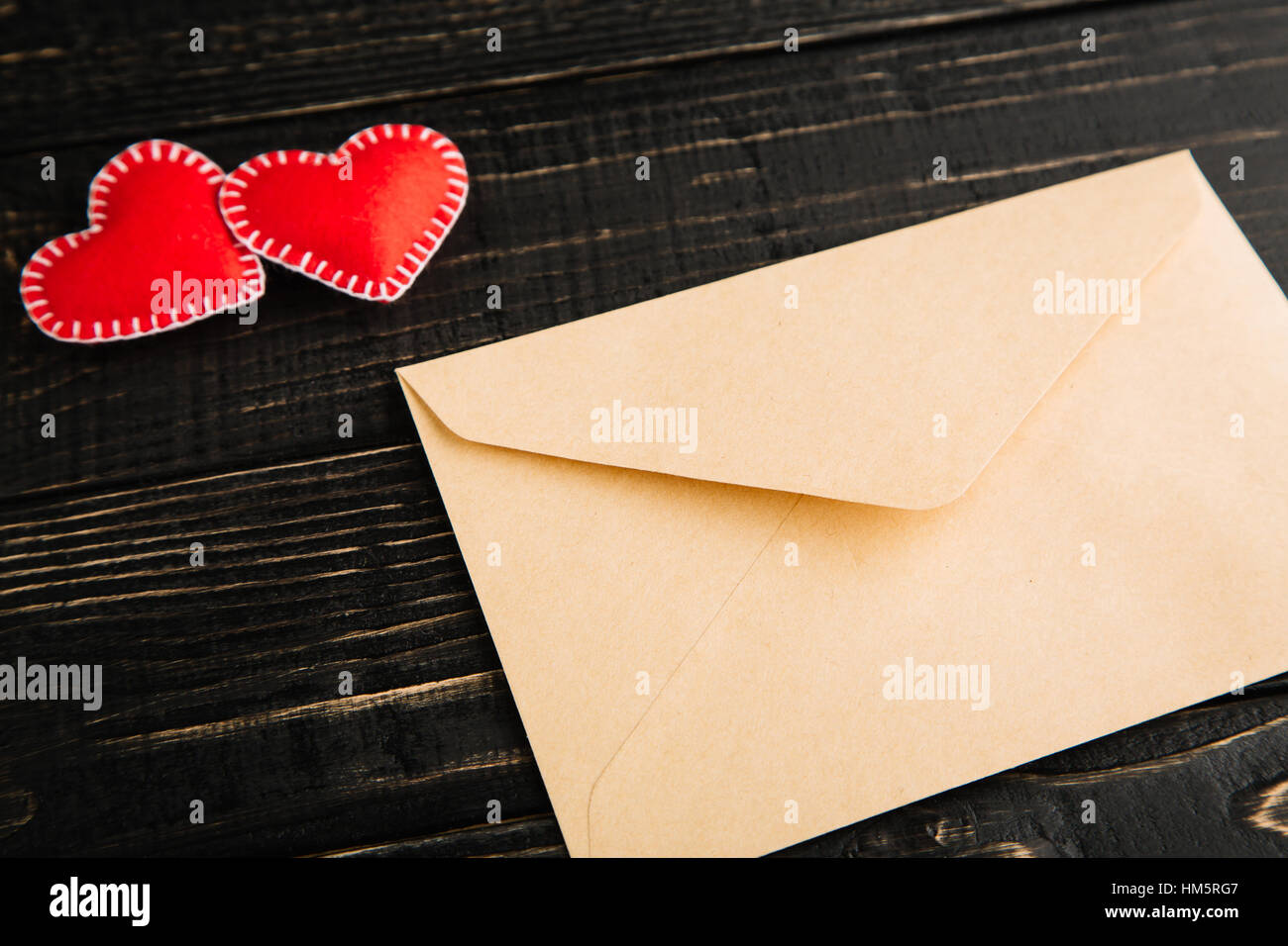 Craft envelope and red handmade hearts from felt on the black rustic ...