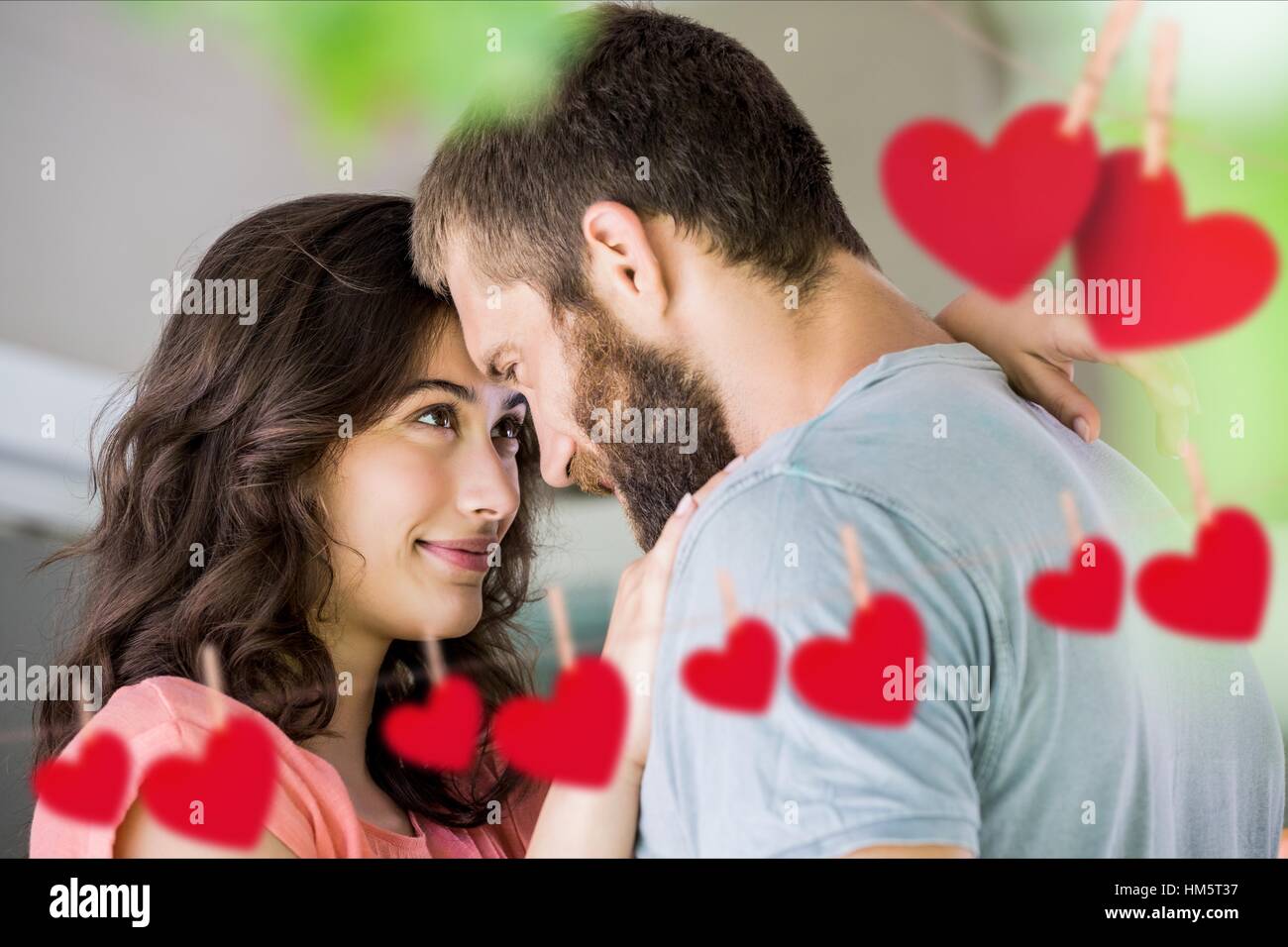 Couple staring at each other with hanging hearts Stock Photo - Alamy