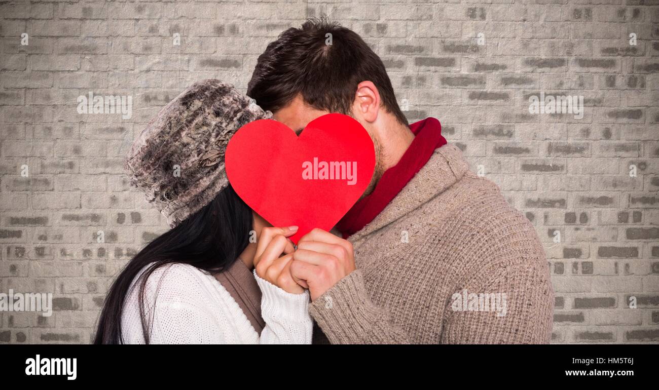 Romantic couple hiding their face behind red heart Stock Photo - Alamy