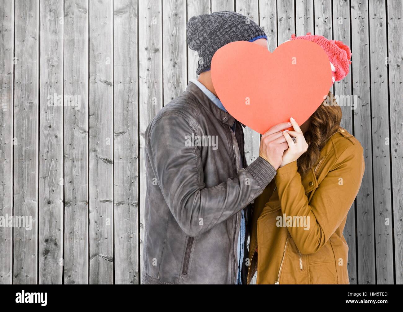 Romantic couple hiding their face behind heart Stock Photo - Alamy