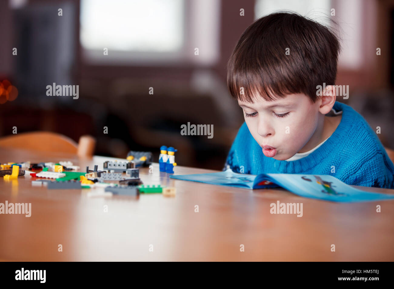 Concentrated child reading a manual Stock Photo - Alamy