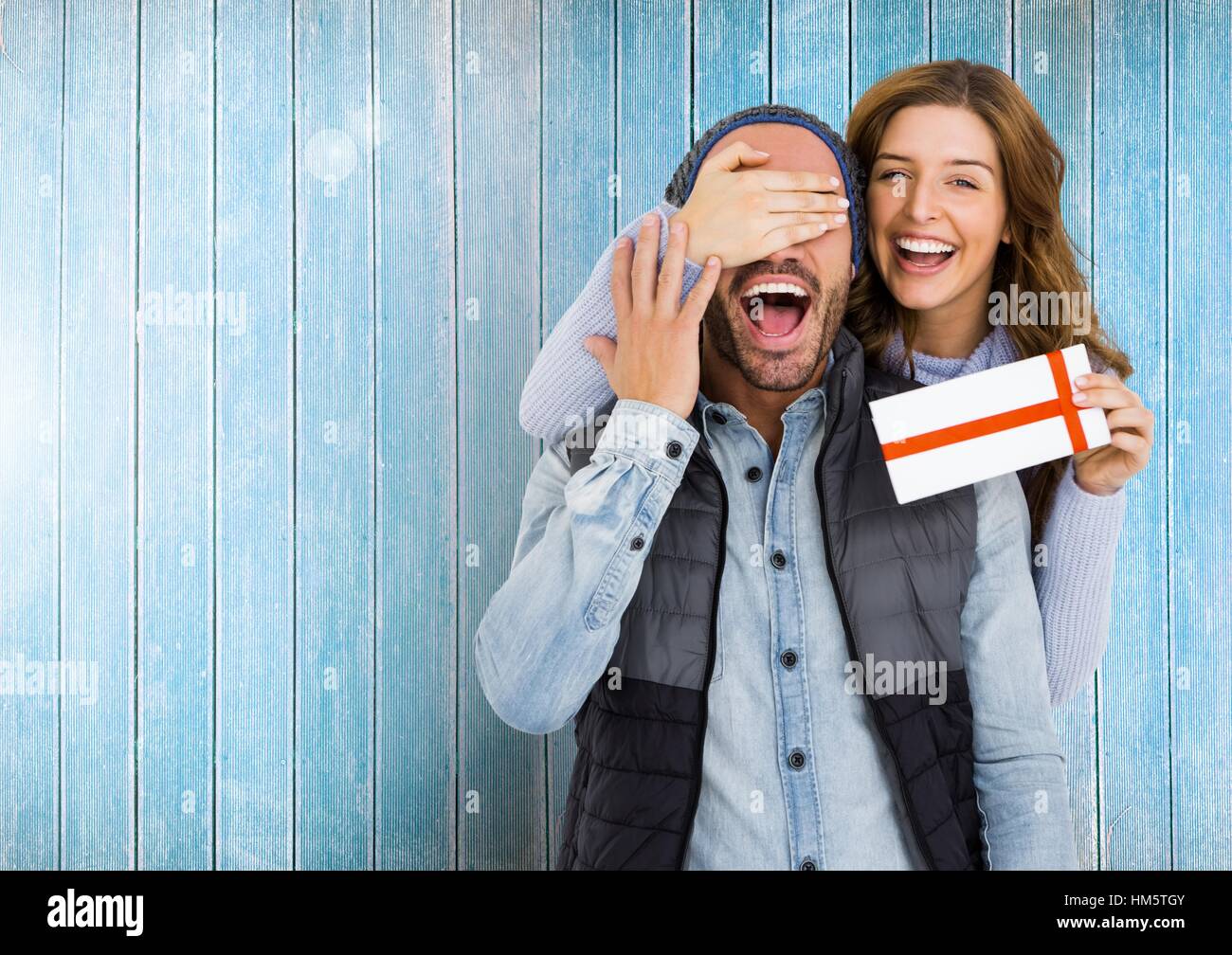 Woman giving surprise gift to man Stock Photo - Alamy