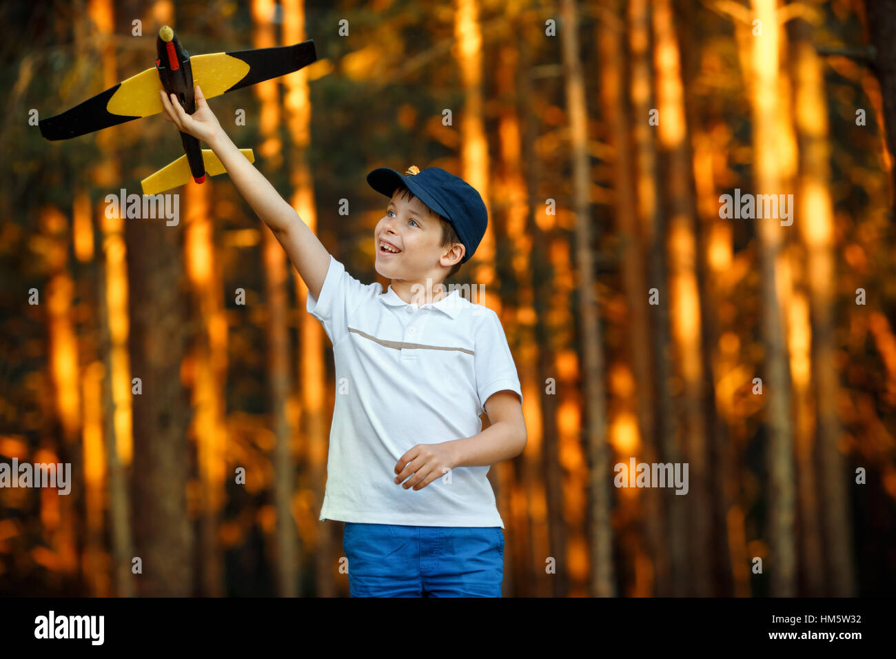 Happy boy playing with toy airplane, sunset forest on background Stock ...