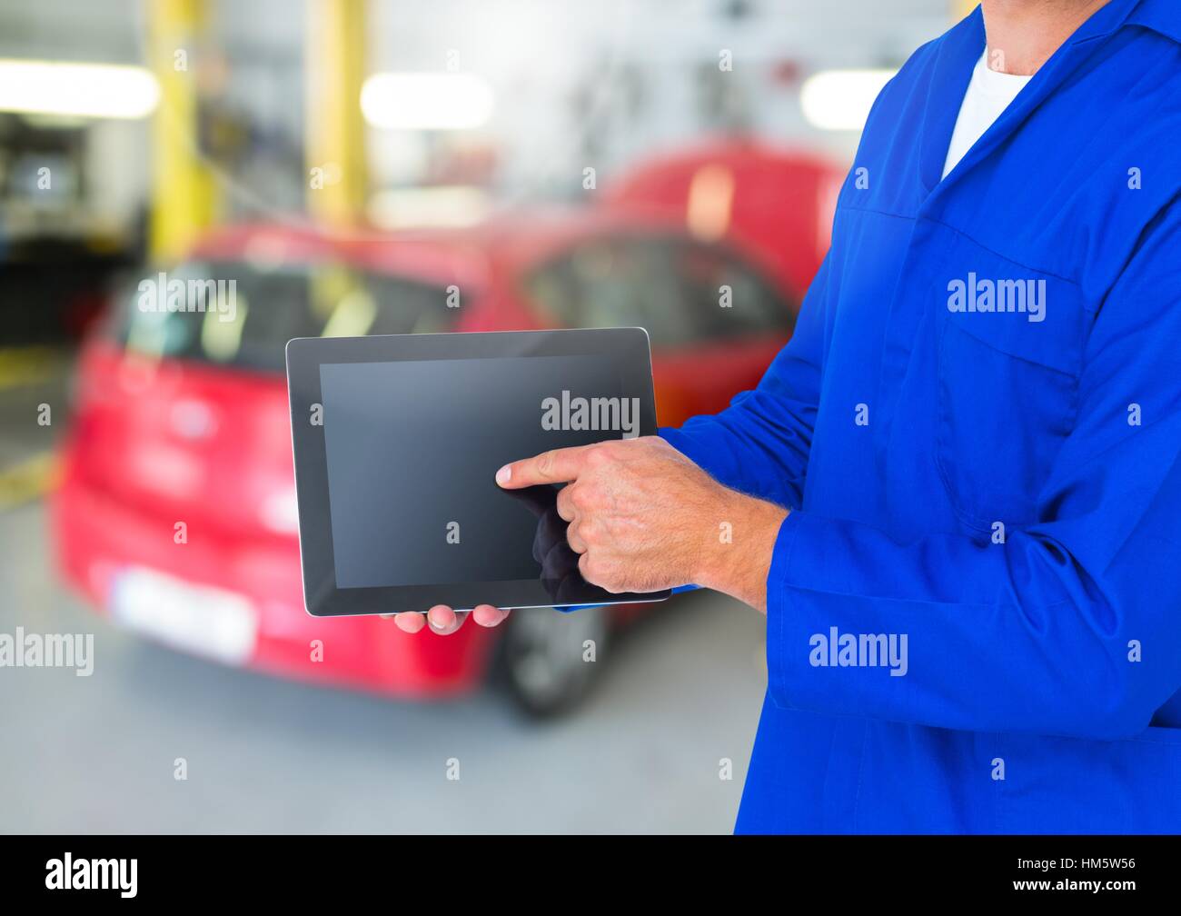 Mechanic using digital tablet in repair garage Stock Photo - Alamy