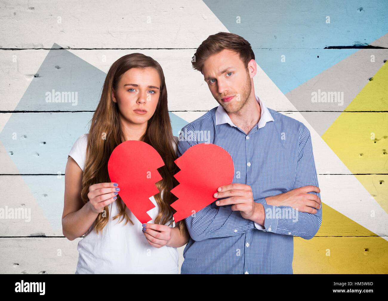 Portrait of sad couple holding broken hearts Stock Photo - Alamy