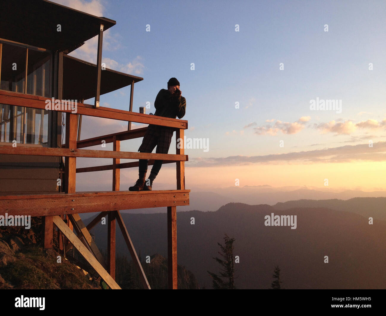 Full length of man leaning on railing at balcony Stock Photo - Alamy