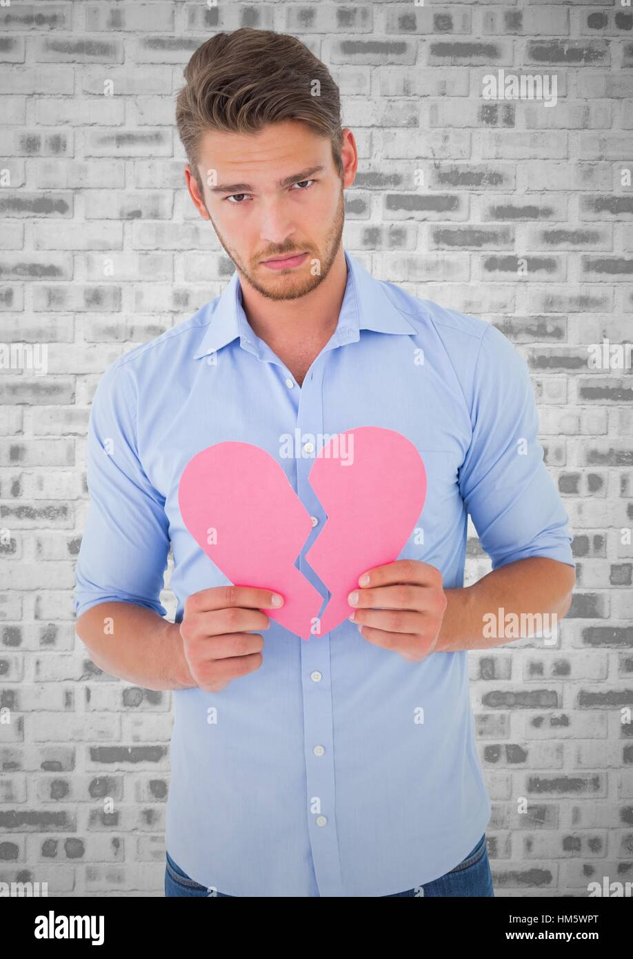 Depressed man holding broken heart Stock Photo - Alamy