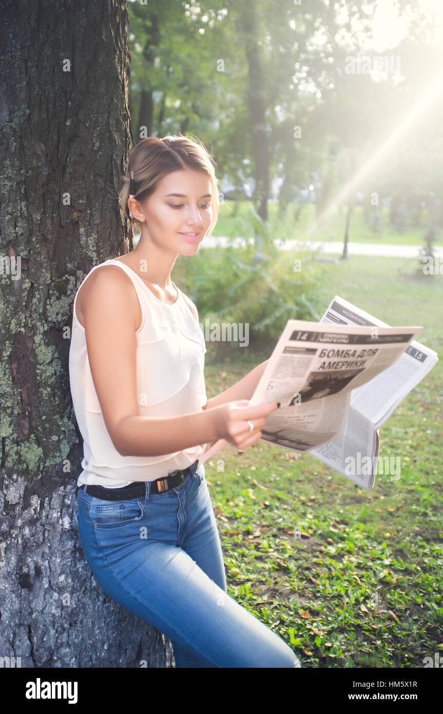 Gorgeous woman reading a magazine in the park Stock Photo - Alamy
