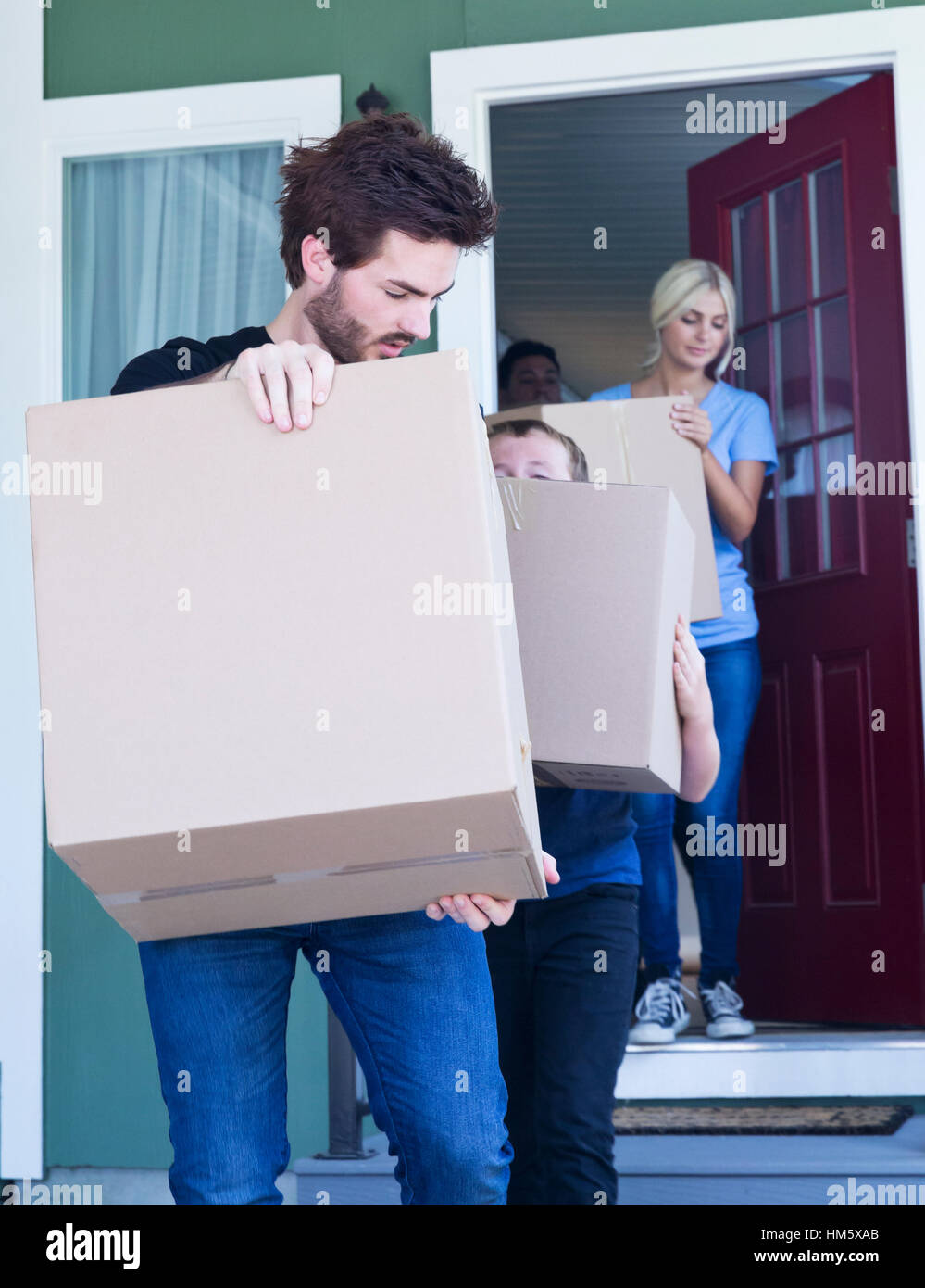Family carrying boxes out of house Stock Photo - Alamy