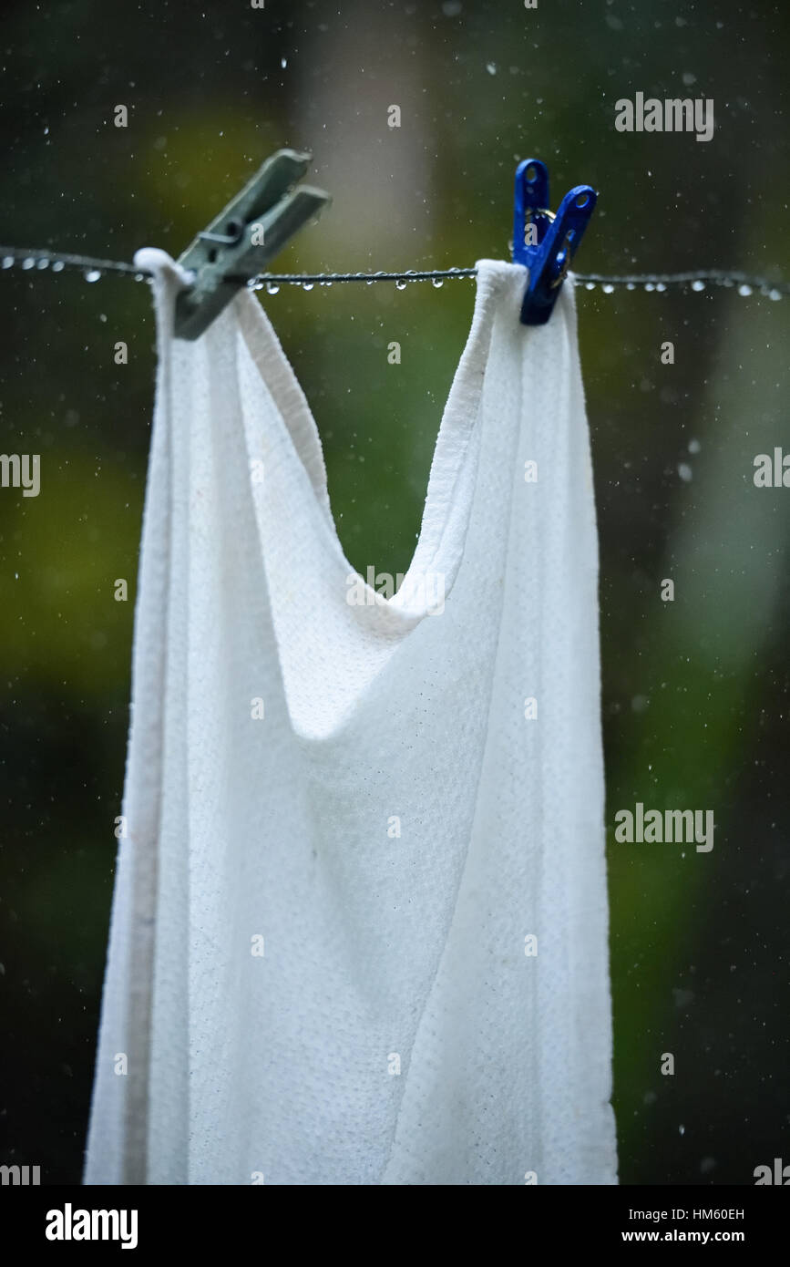 pegs hold white cloth during summer heavy rain Stock Photo - Alamy