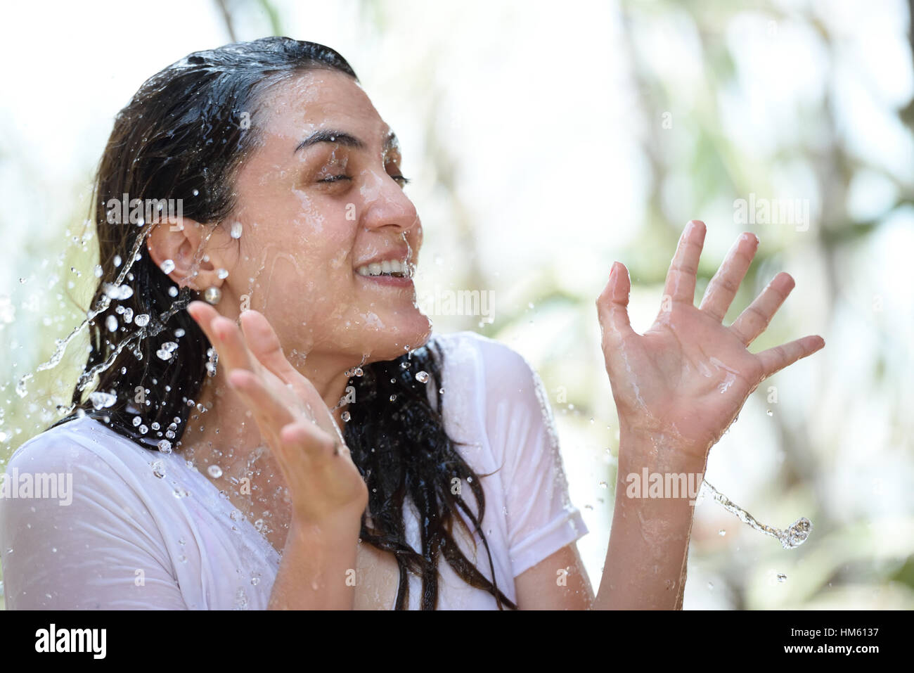 Girl getting splashed on the face by surprise Stock Photo - Alamy