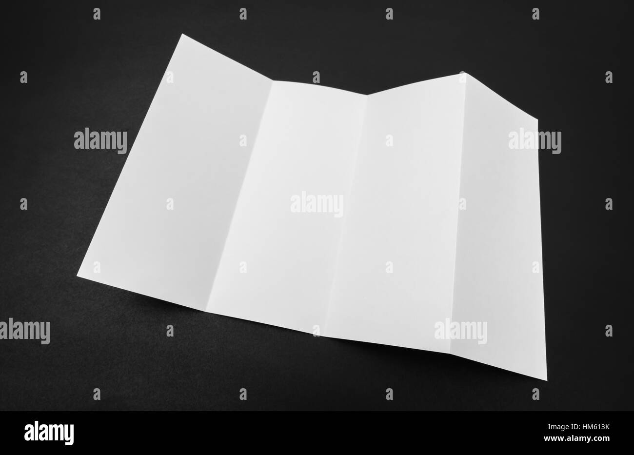 Four - fold white template paper on black background Stock Photo - Alamy