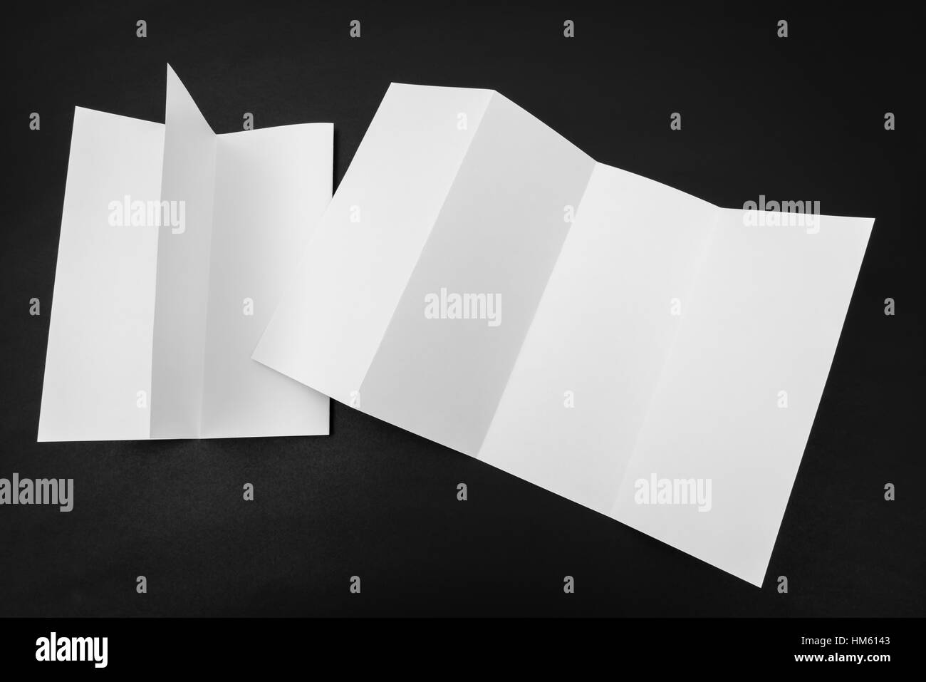 Four - fold white template paper on black background Stock Photo - Alamy
