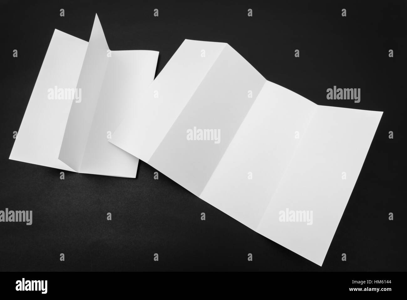 Four - fold white template paper on black background Stock Photo - Alamy