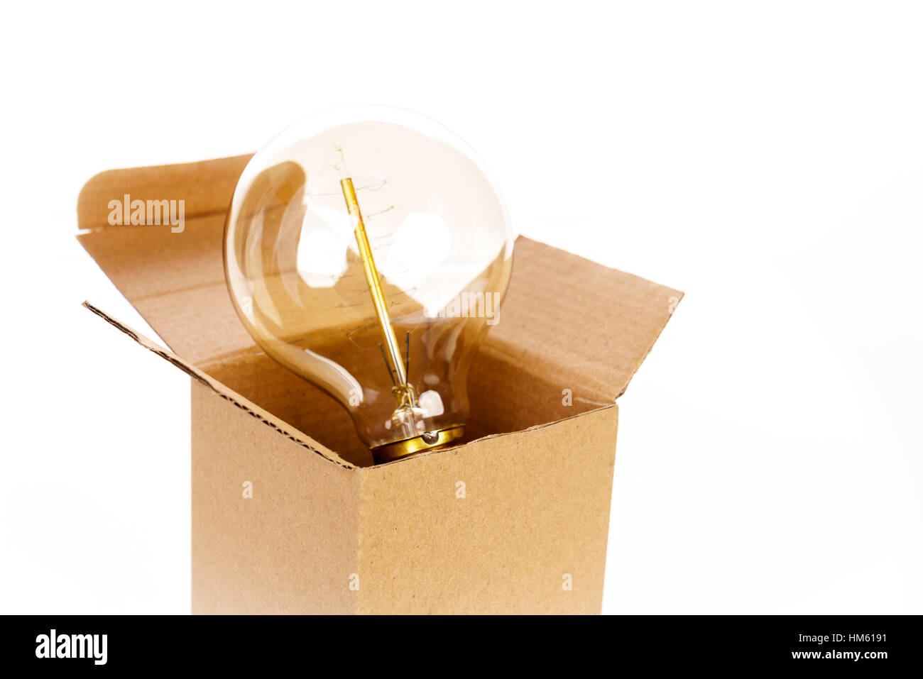 Glowing light bulb over open cardboard box Stock Photo - Alamy