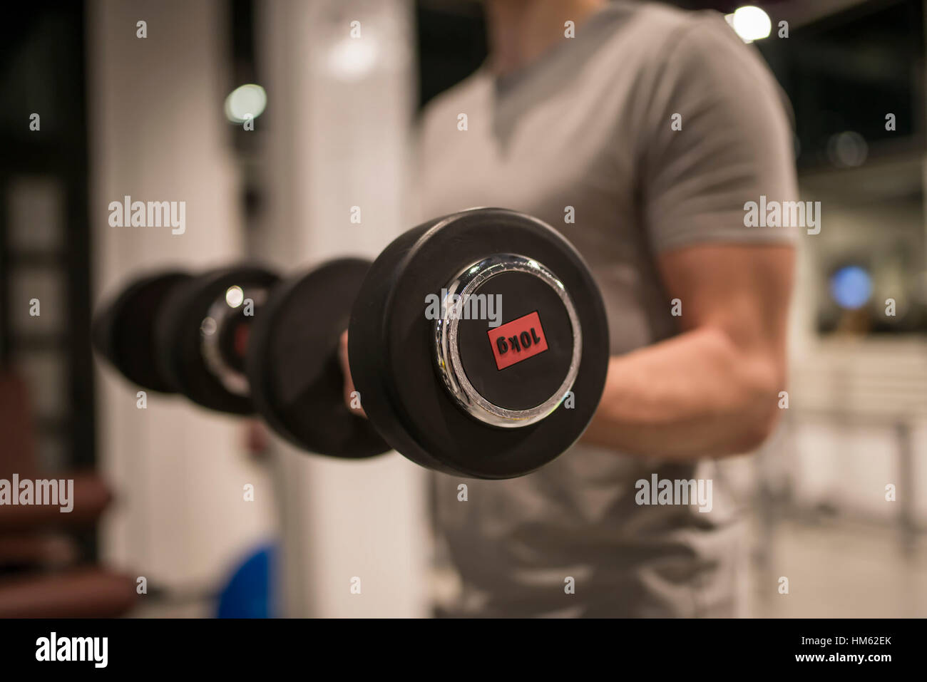 Muscular man training with red dumbbell in the gym Stock Photo - Alamy