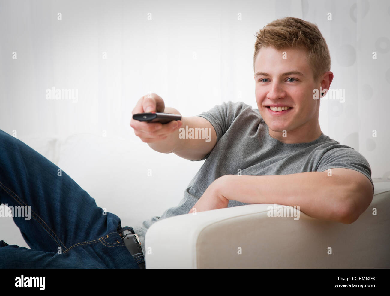 Young man watching tv Stock Photo - Alamy