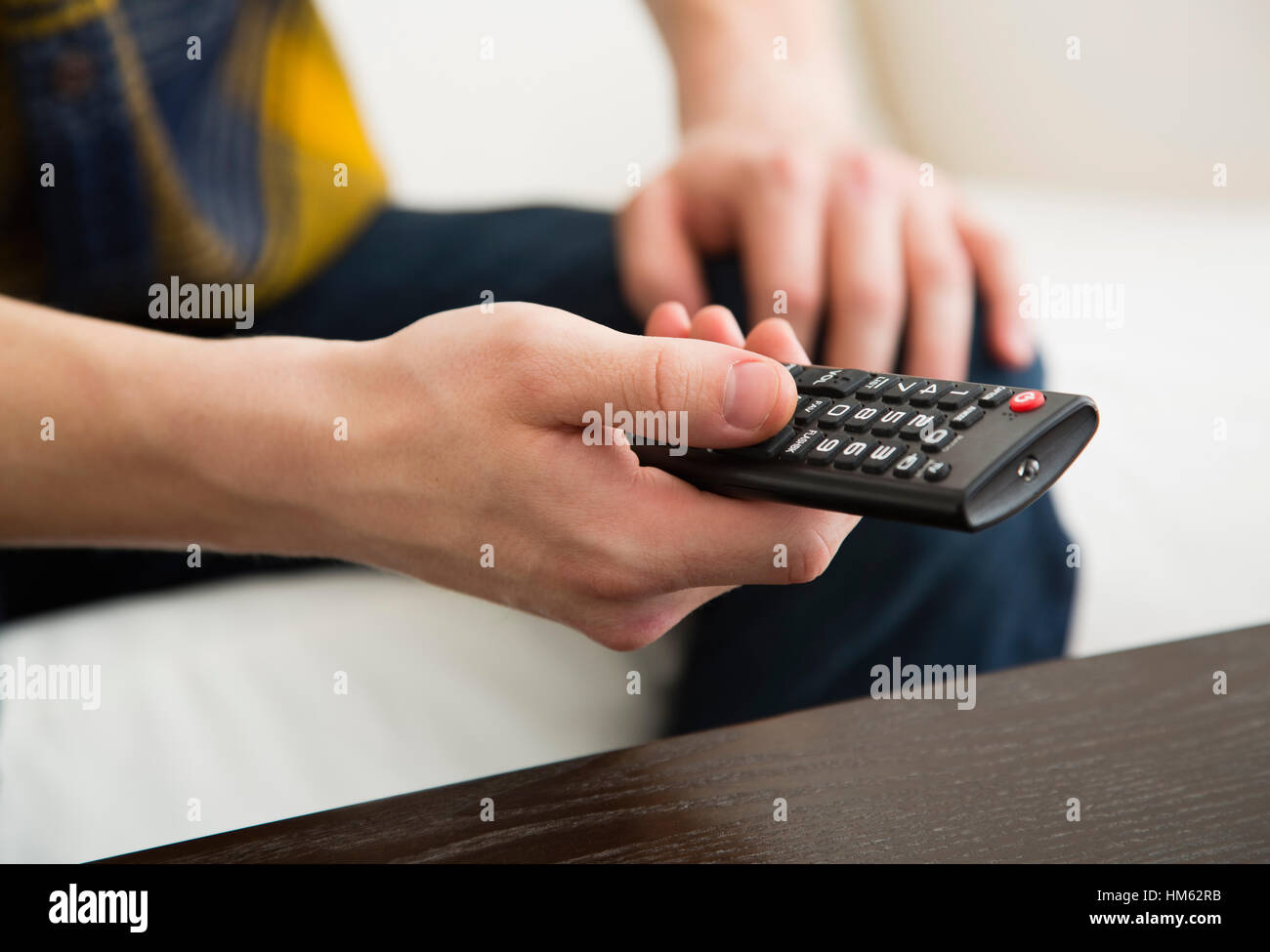 Young man using remote Stock Photo - Alamy