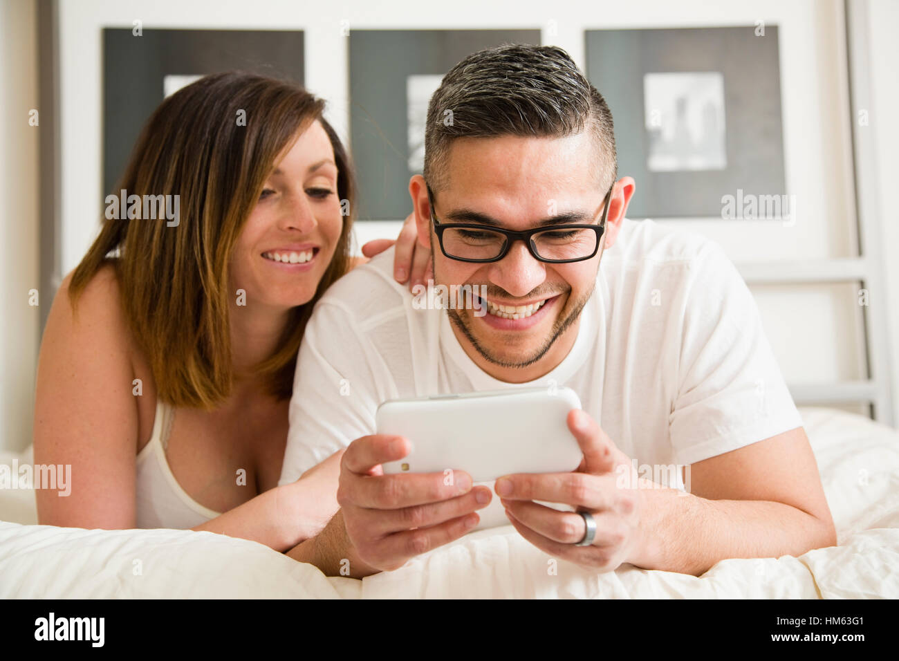 Young couple using phone together Stock Photo - Alamy