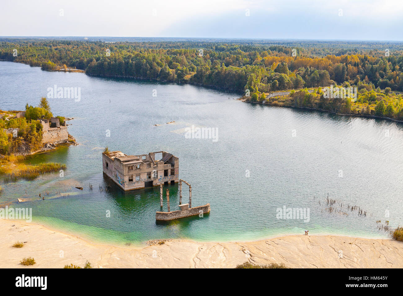Sand hills of quarry with a pond and abandoned prison in Rummu, Estonia ...