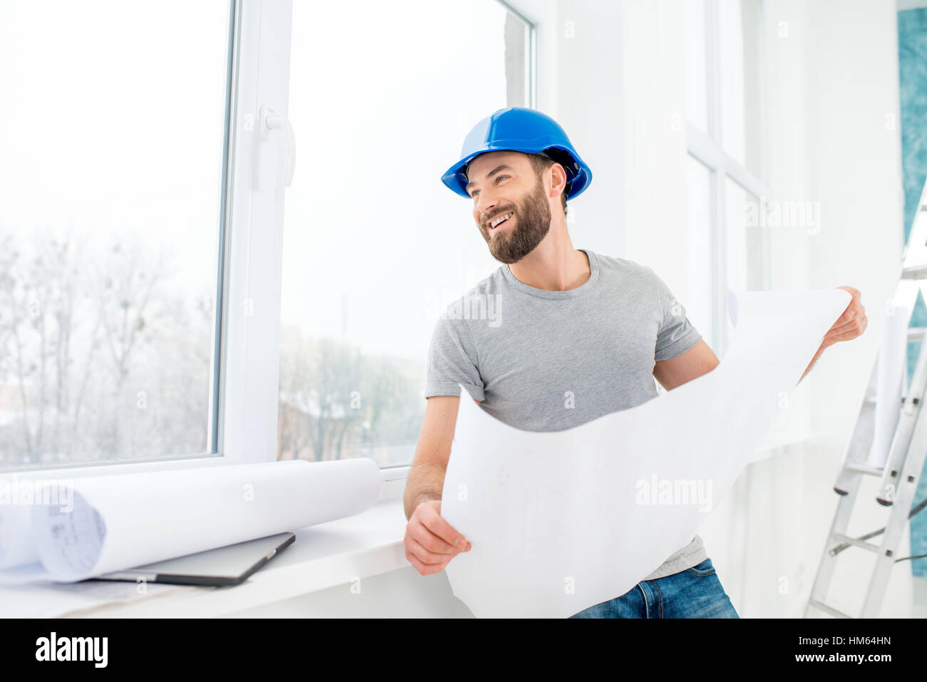 Foreman or builder with drawings Stock Photo - Alamy