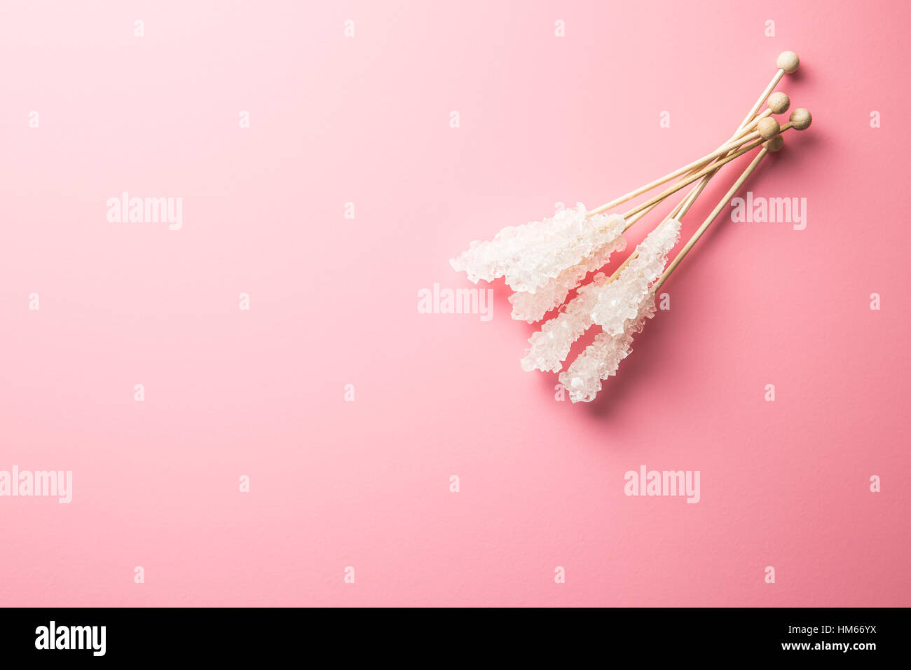 Crystallized sugar on wooden stick on pink background. Top view Stock ...