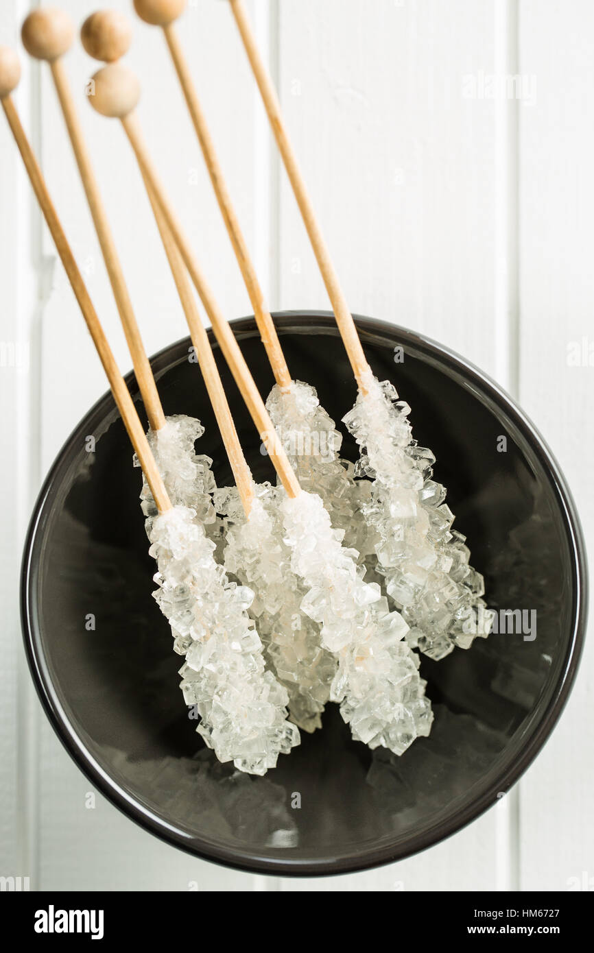 Crystallized sugar on wooden stick in bowl. Top view Stock Photo - Alamy